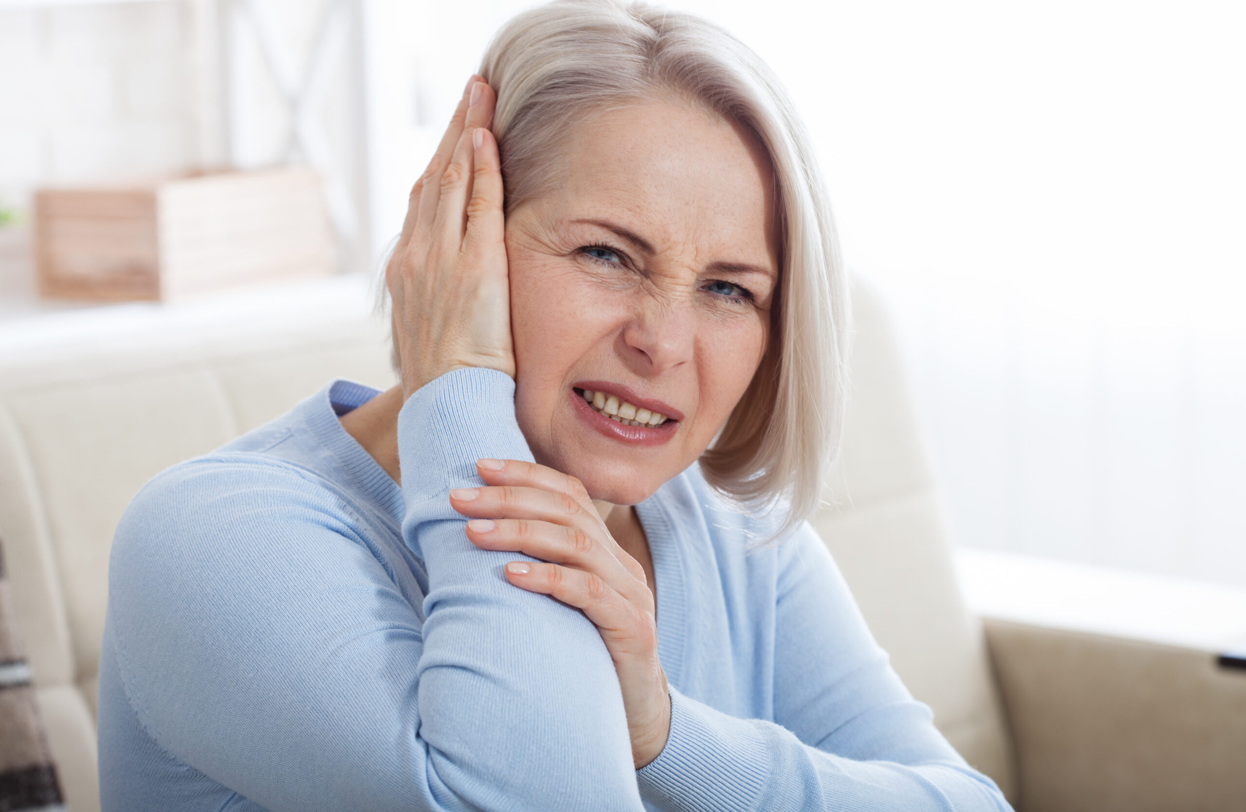 Tinnitus. Closeup up side profile sick female having ear pain touching ...